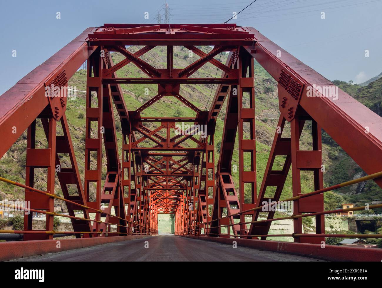 A striking red Truss Rod iron bridge spanning the Ravi River near the ...