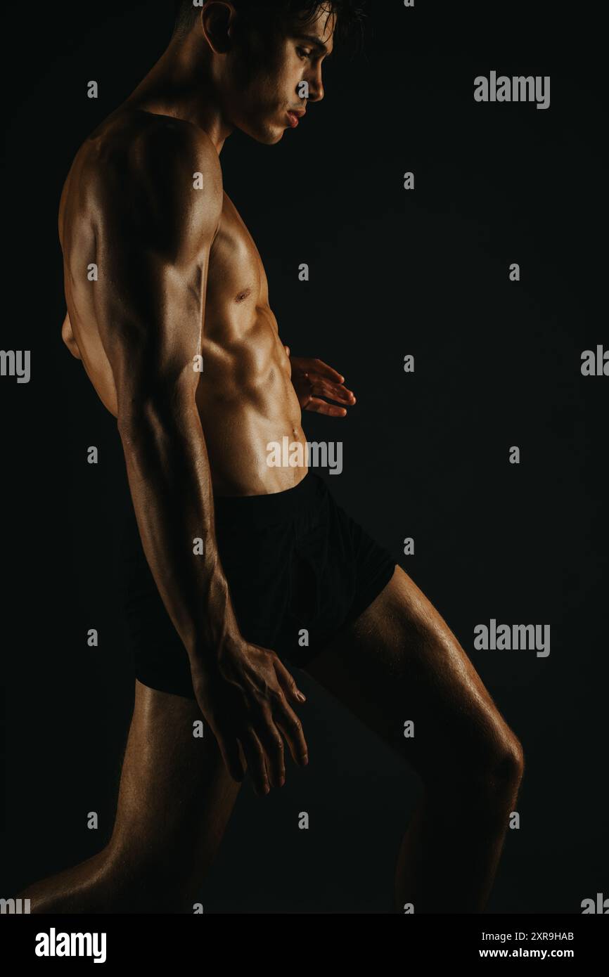 Fit male showcasing abs and arm muscles, demonstrating a fit body in a ...