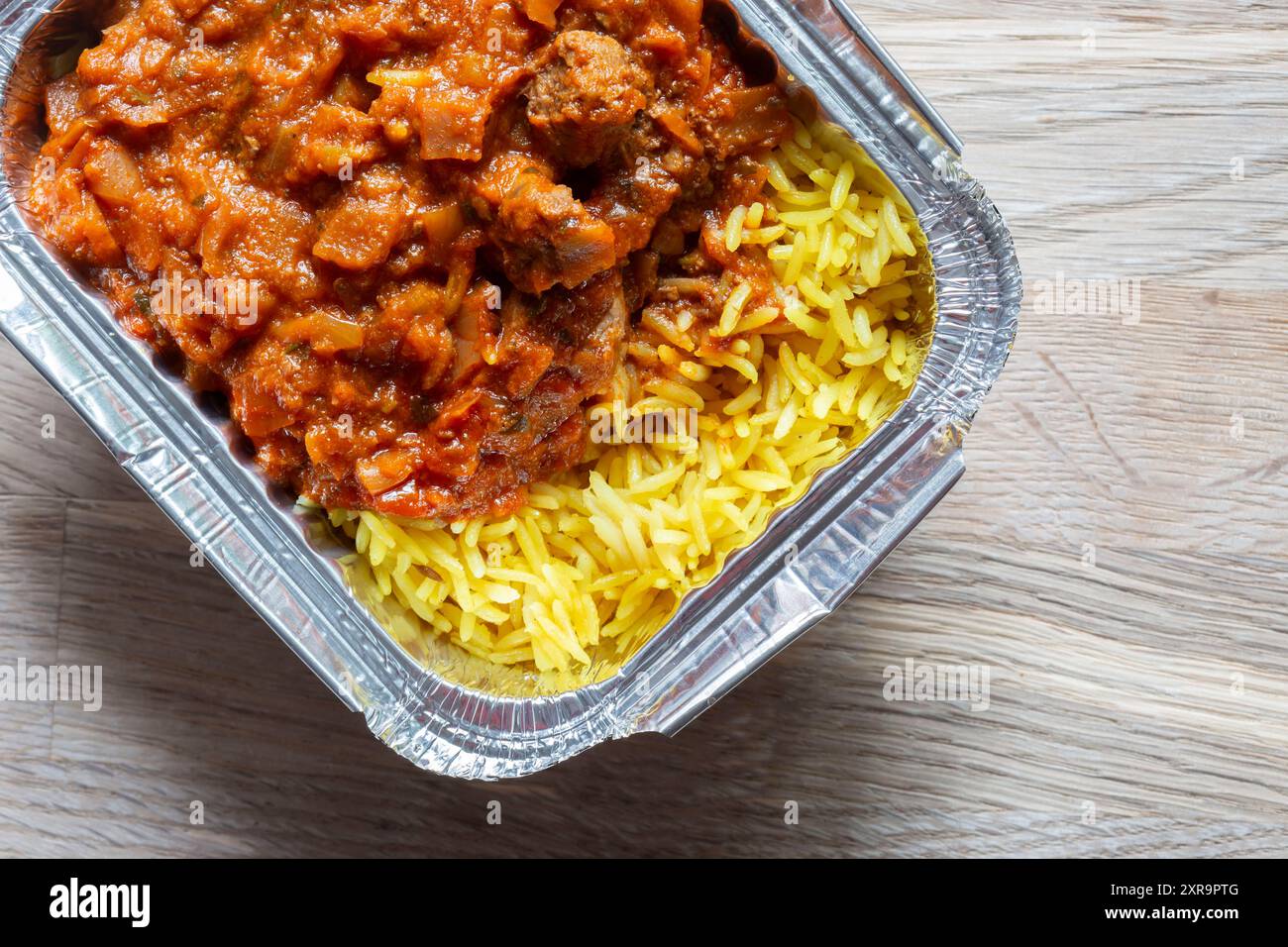 Lamb Rogan Josh Indian curry with pilau rice takeaway meal in foil tray ...