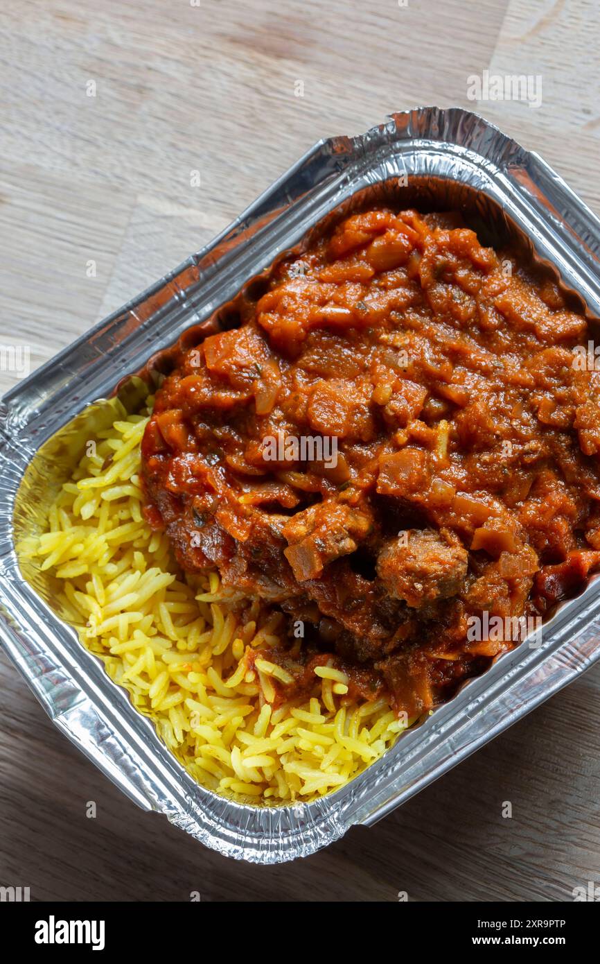 Lamb Rogan Josh Indian curry with pilau rice takeaway meal in foil tray ...