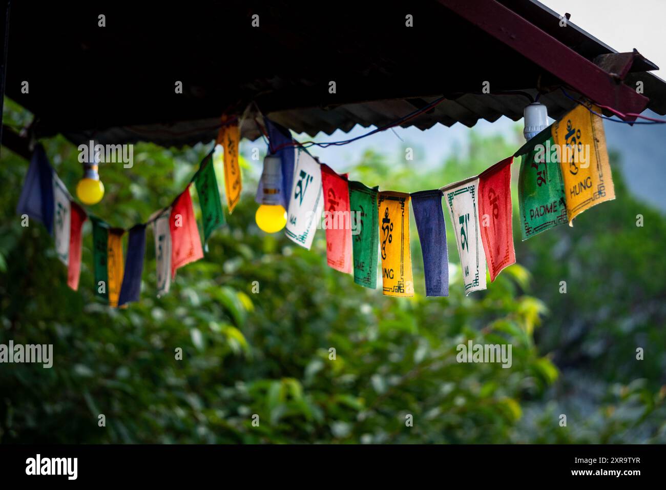 Beautifully colored prayer flags hanging outside a balcony roof, set ...