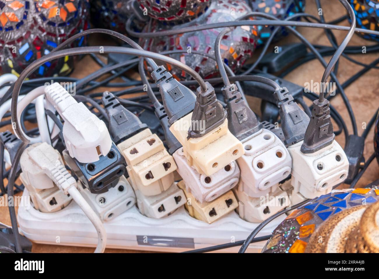 Old and damaged electric adapter power plug has many appliances are ...