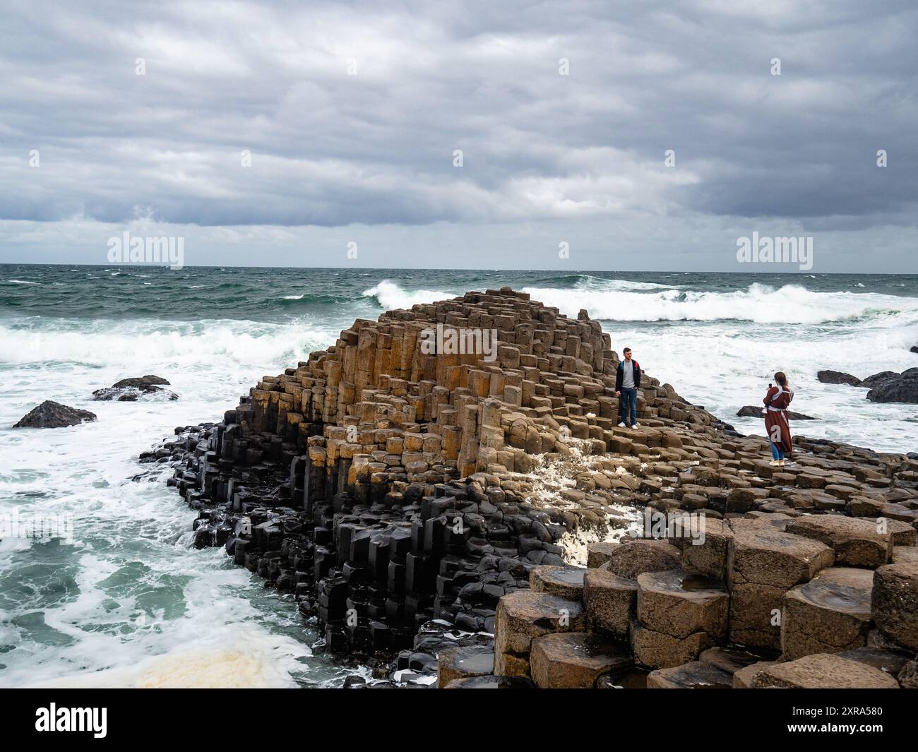 A couple taking photos at the photogenic spot. The Giant’s Causeway and ...