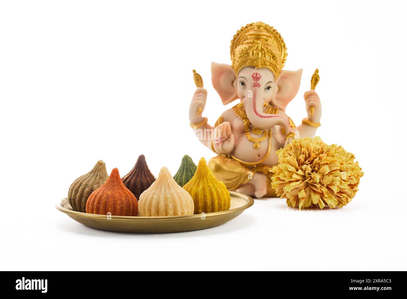 Ganesh Chaturthi Festival. Ganesha idol with colorful Modaks on a white ...