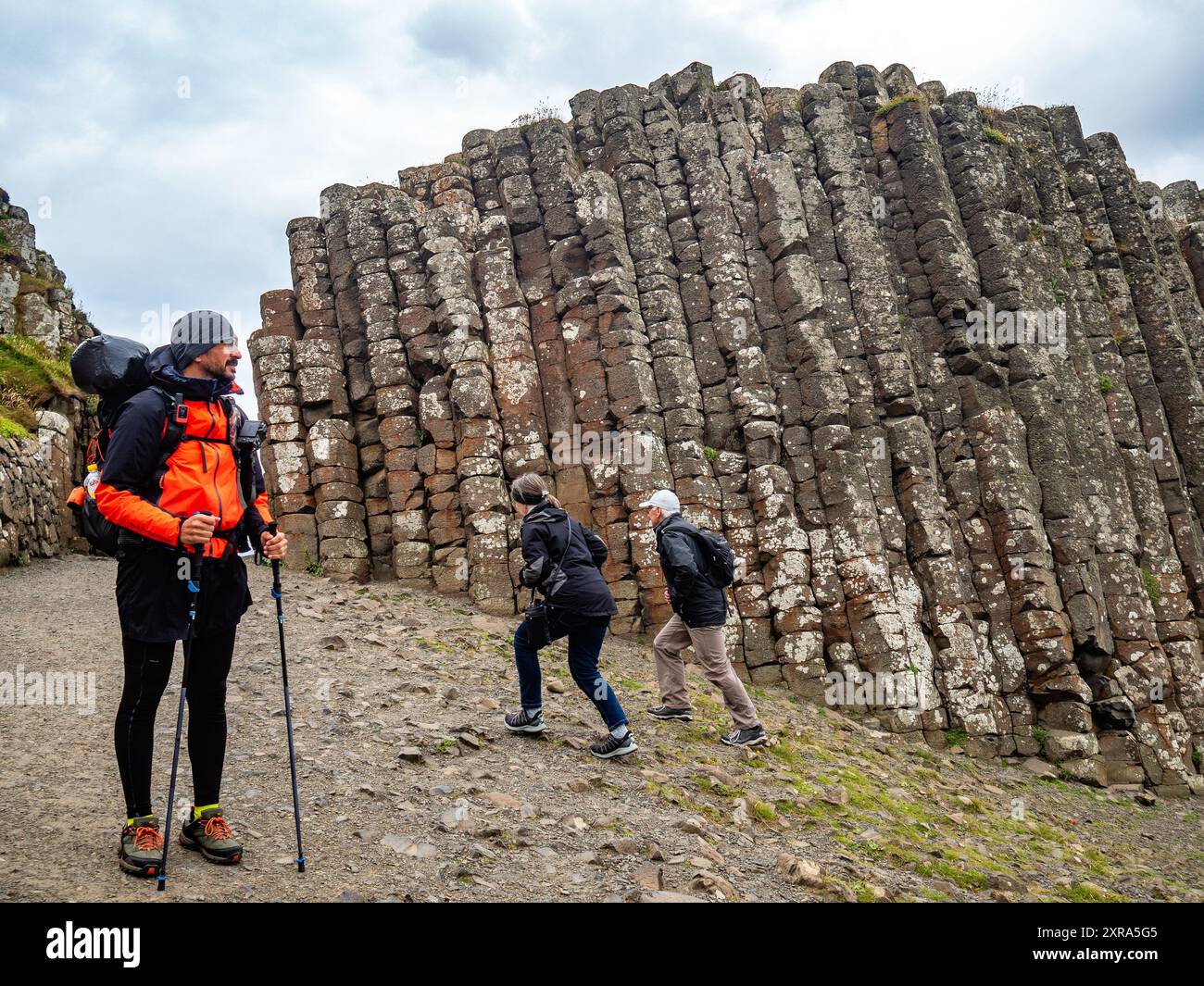 People walk by the basalt stone columns. The Giant’s Causeway and ...