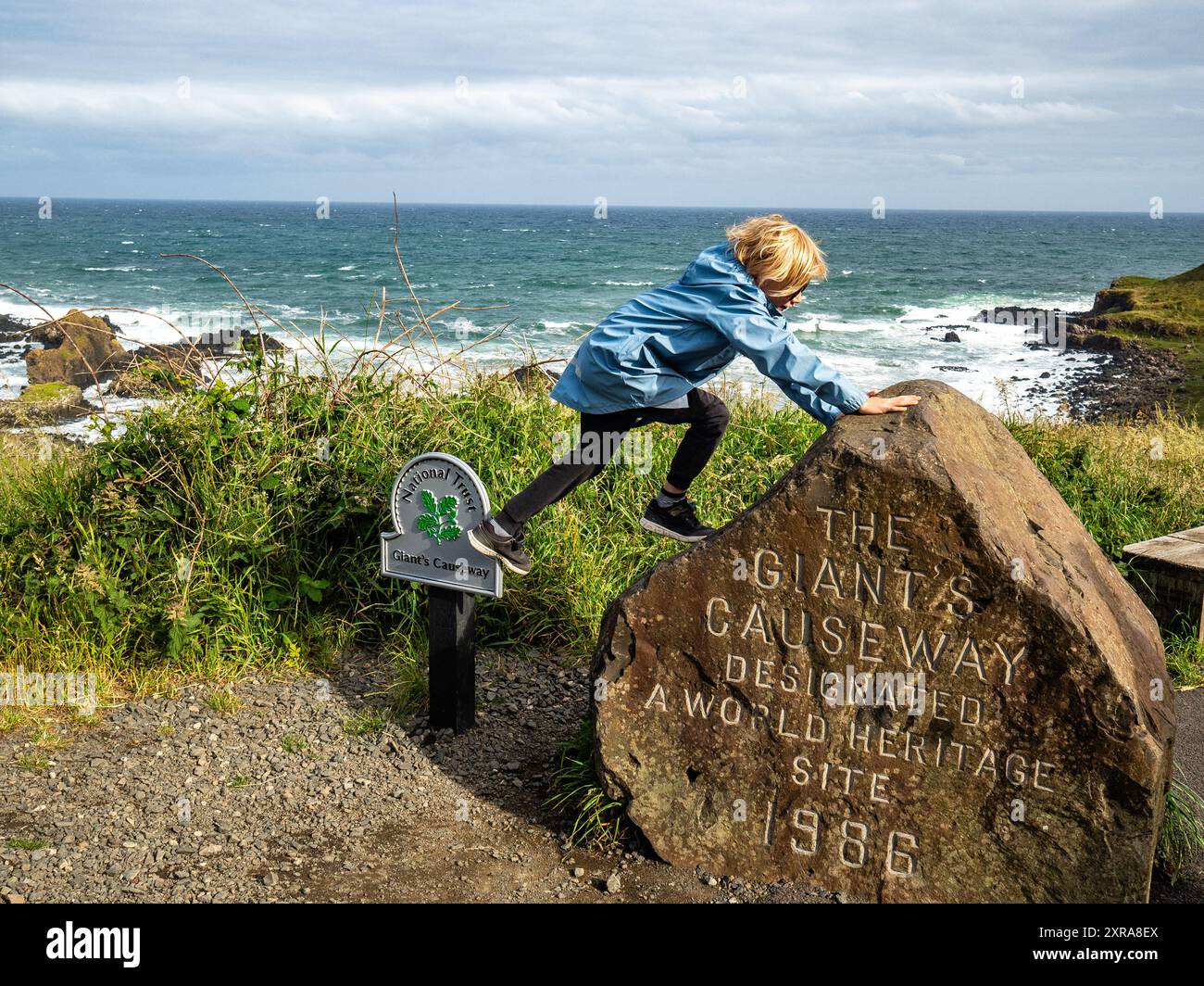 A boy climbing the stone with the information about this natural ...