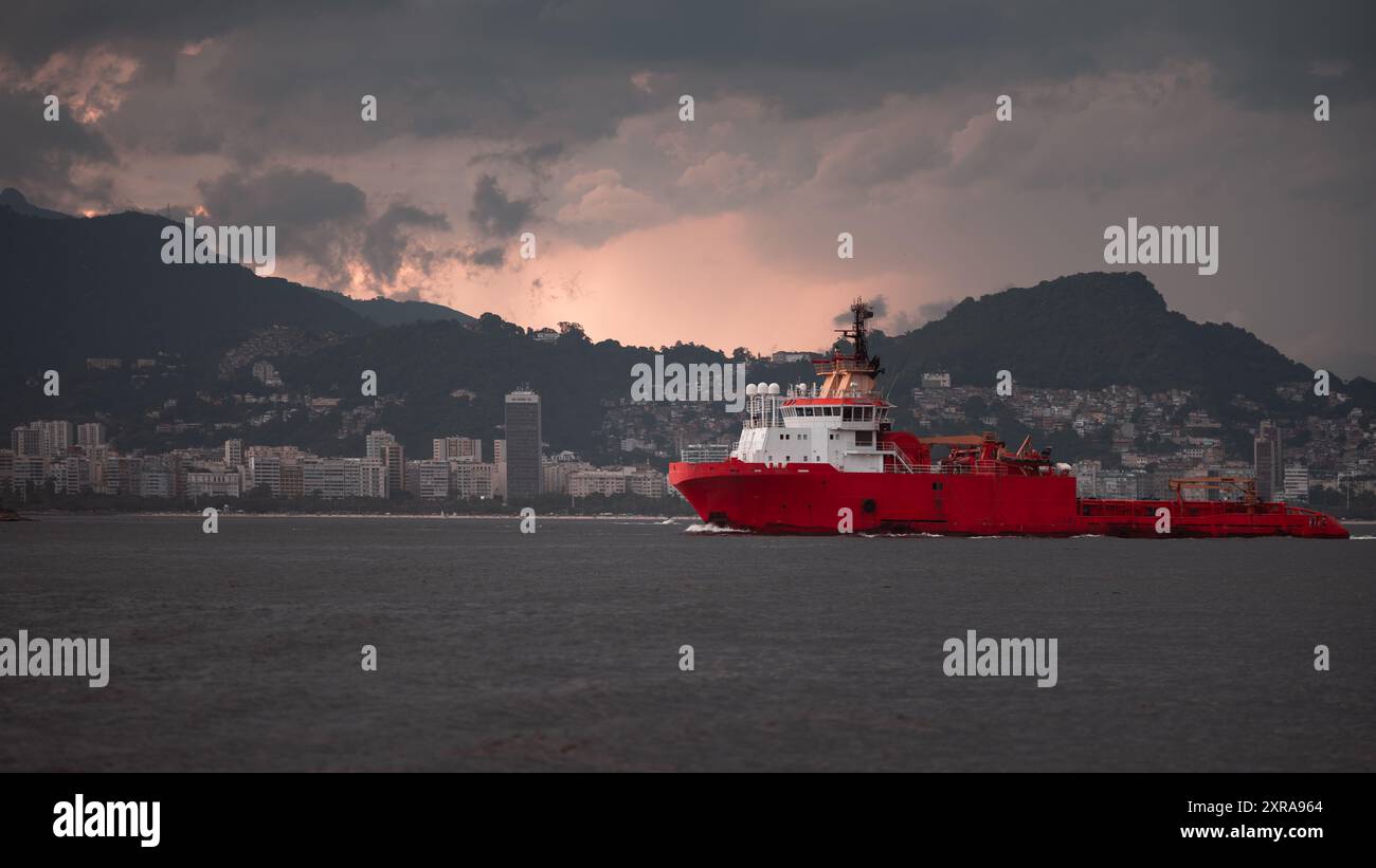 A large red offshore supply vessel navigates through the waters near ...