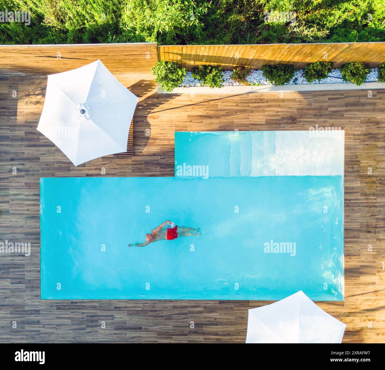 Man swimming alone in the luxury villa swimming pool. Aerial top view ...