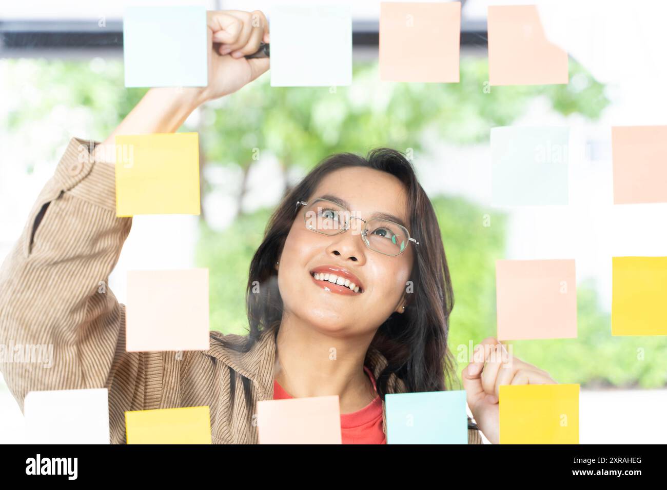 A businesswoman uses sticky notes to visualize her goals and dreams on ...