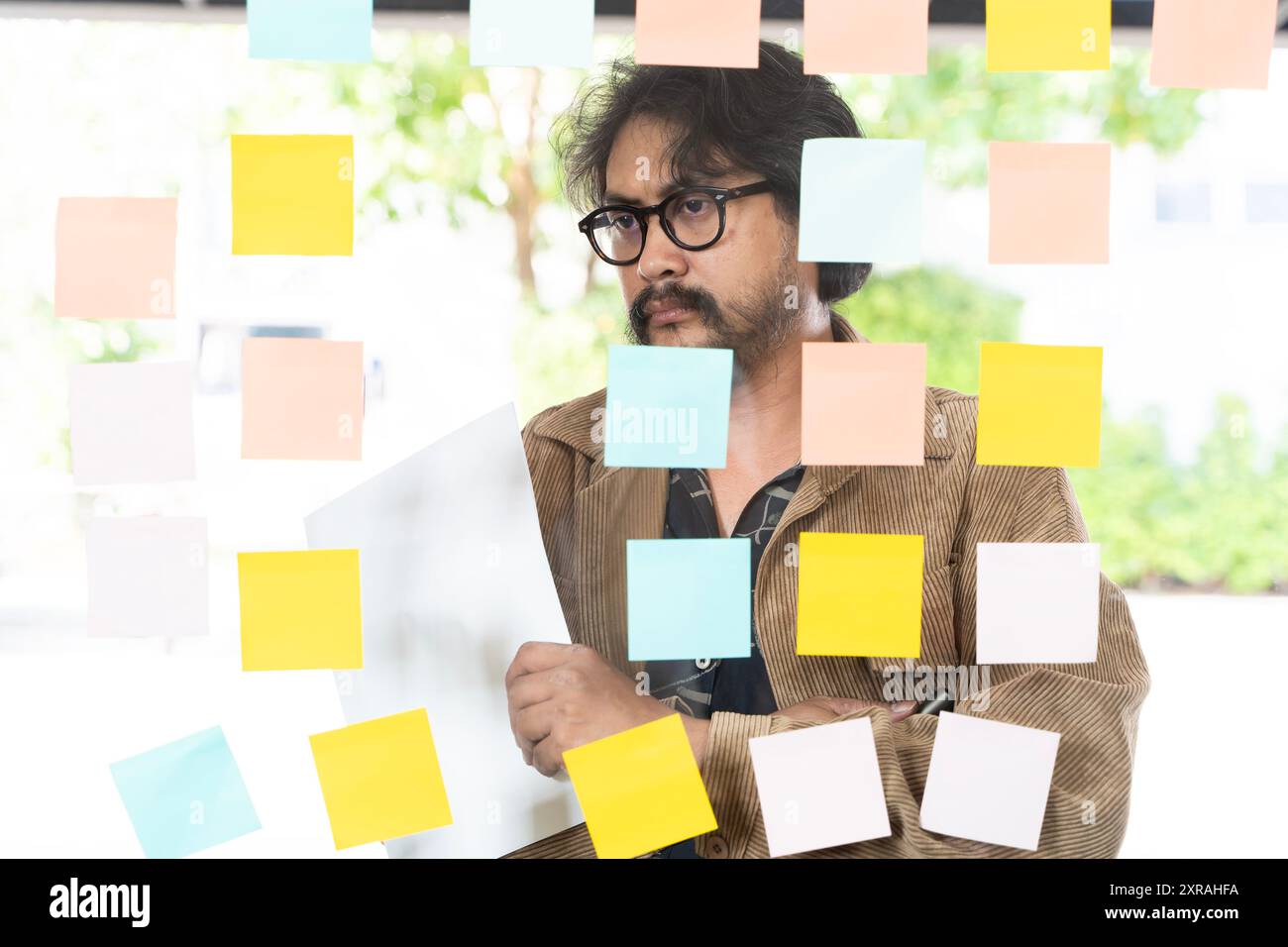 A creative professional brainstorming new ideas by writing them on ...