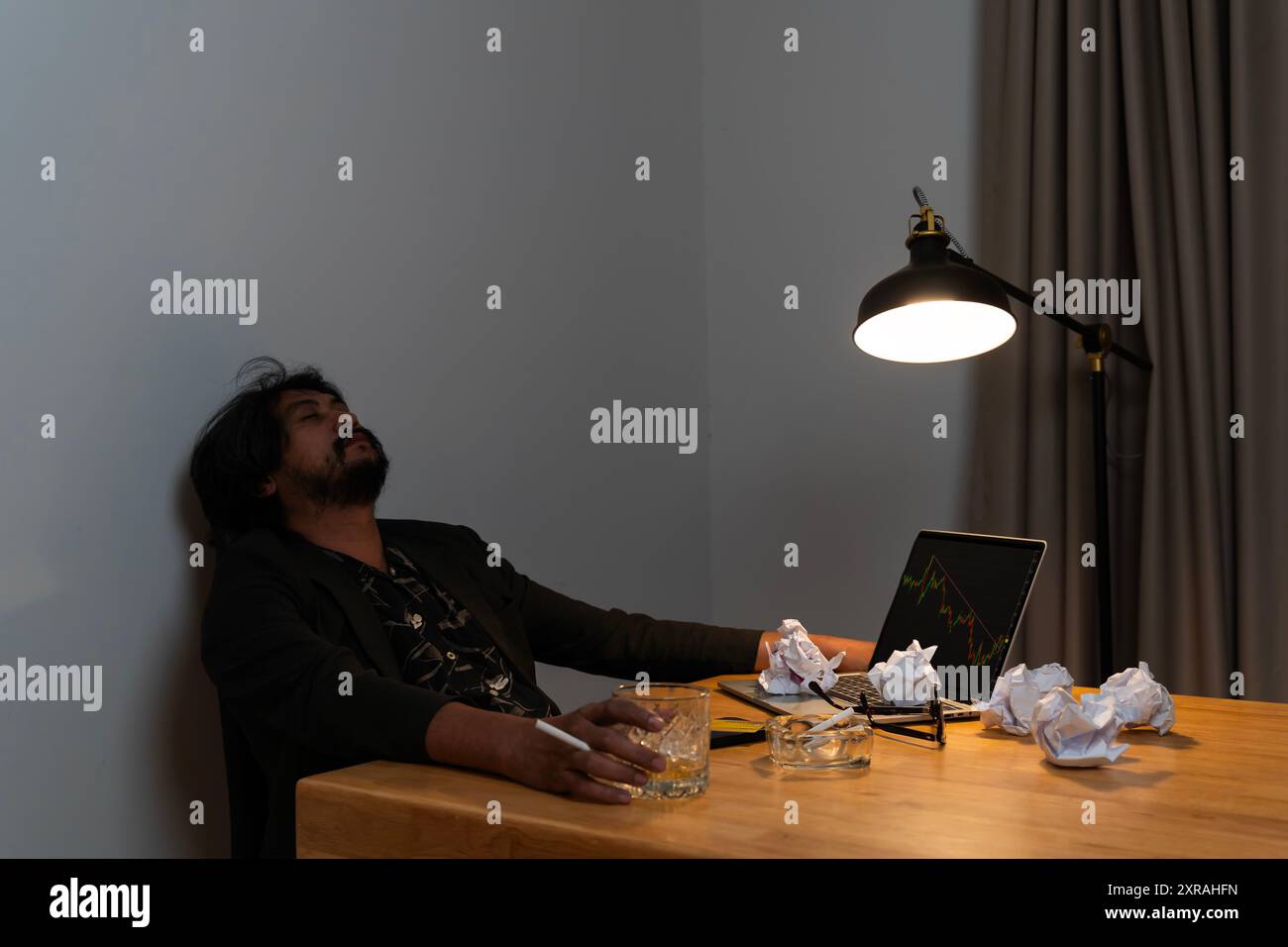 A disheveled man sits in his living room, surrounded by empty bottles ...