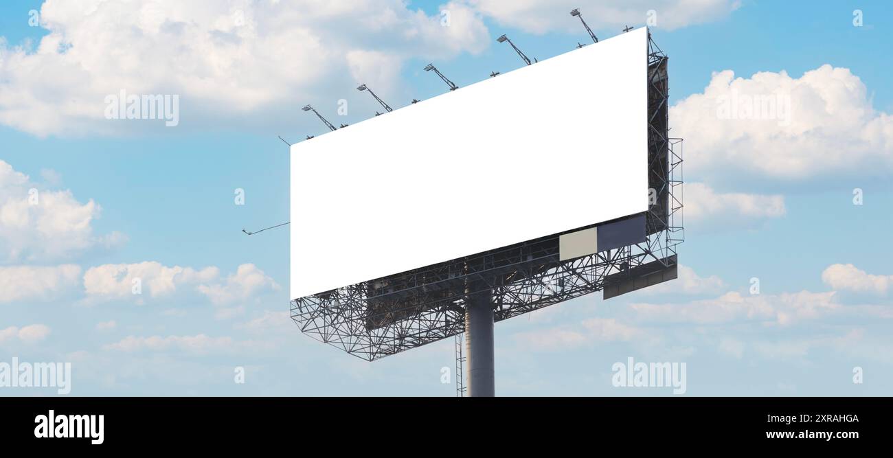 A large billboard against a blue sky with some clouds. The billboard is ...