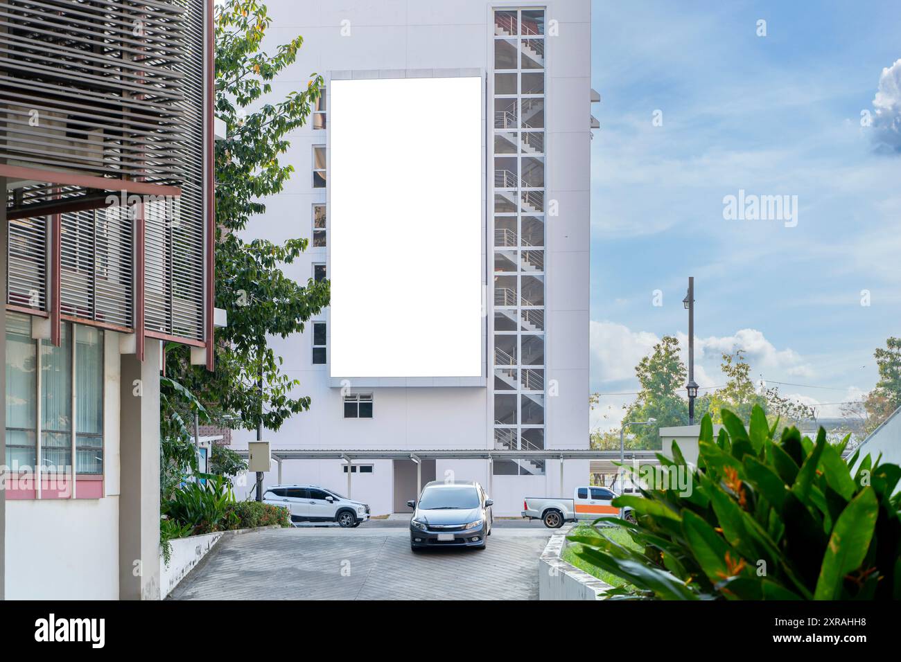 A large blank billboard stands on the side of a tall, modern building ...
