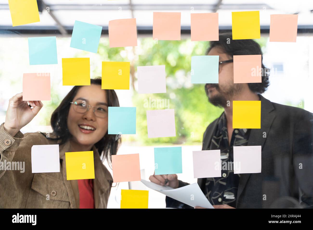 Business people meeting at office and using post notes to share ideas ...