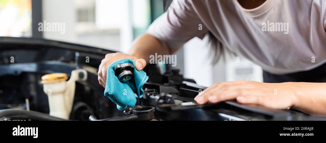 This woman may be checking the coolant level or looking for a leak. A ...