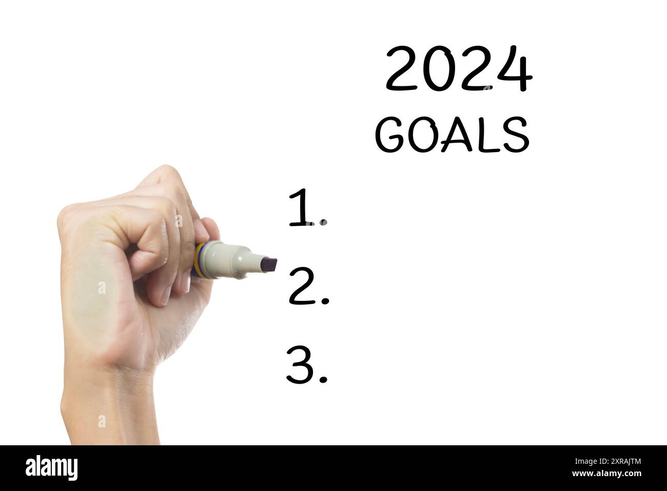 A person writing their goals for 2024 on a glass whiteboard. They are ...