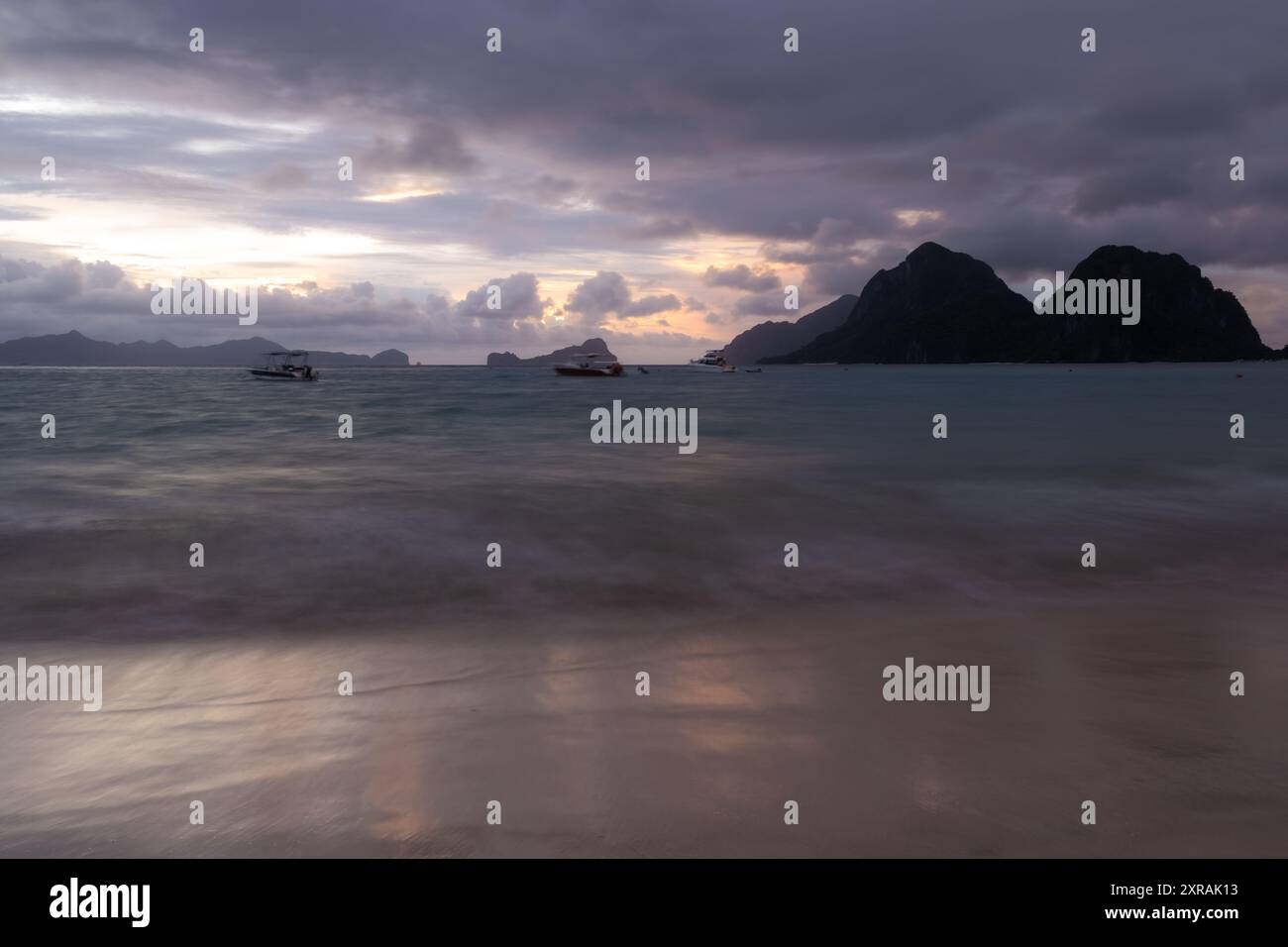 Long exposure of the ocean at sunset at Las Cabanas Beach, El Nido in ...