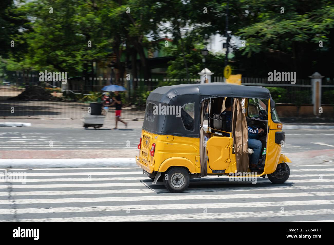 Yellow tuk-tuk driving in the streets of Manila, Philippines Stock ...