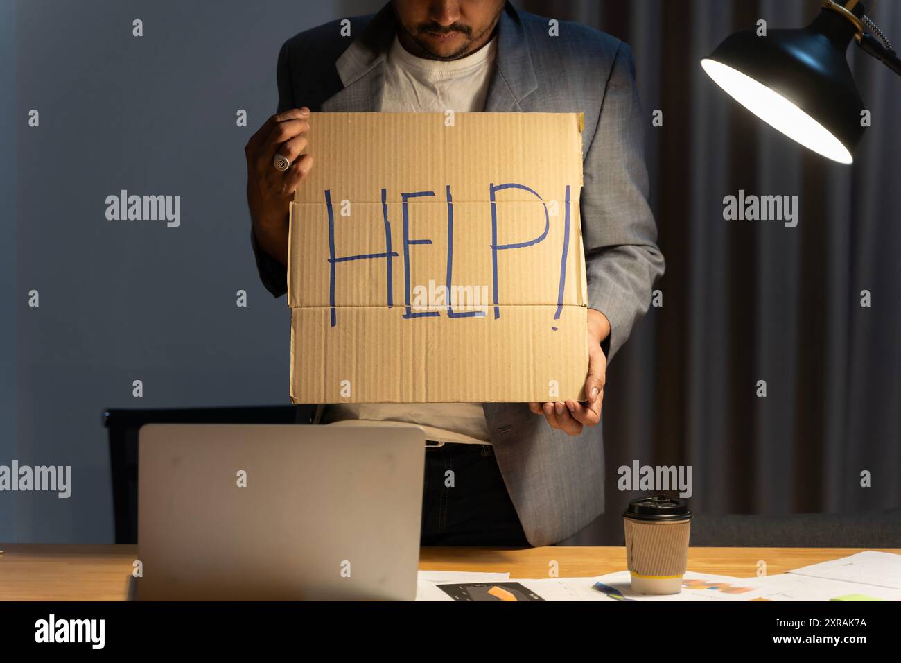 Young businessman working on computer laptop asking for help holding ...