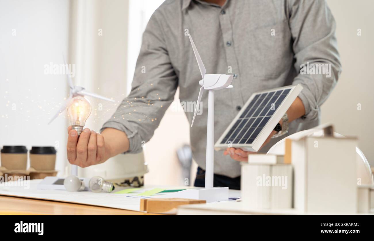 Close-up at a light bulb, An engineer sits holding a light bulb and ...
