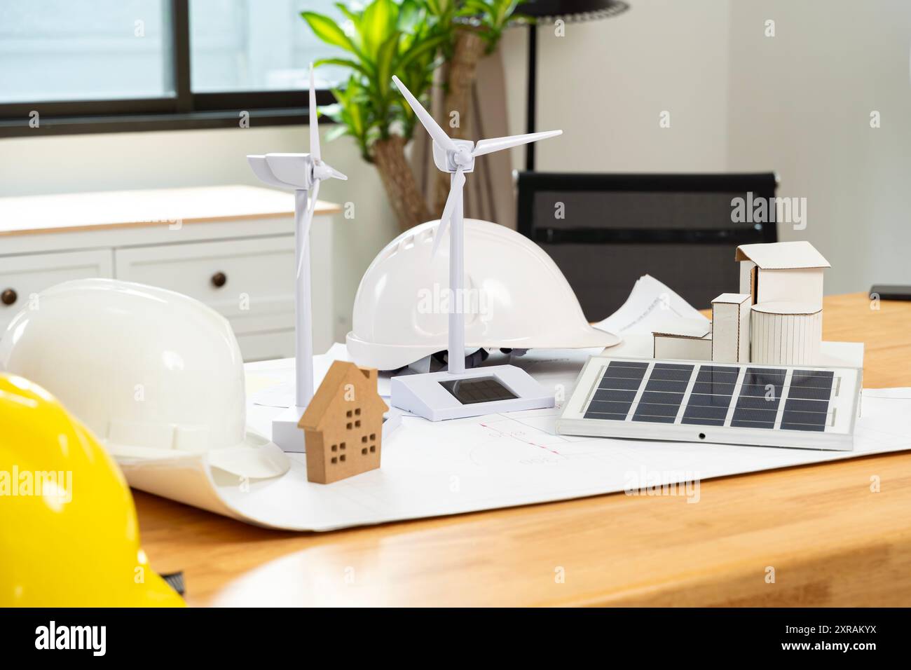 Wind turbines and solar cells A white and yellow engineer's hat sits on ...