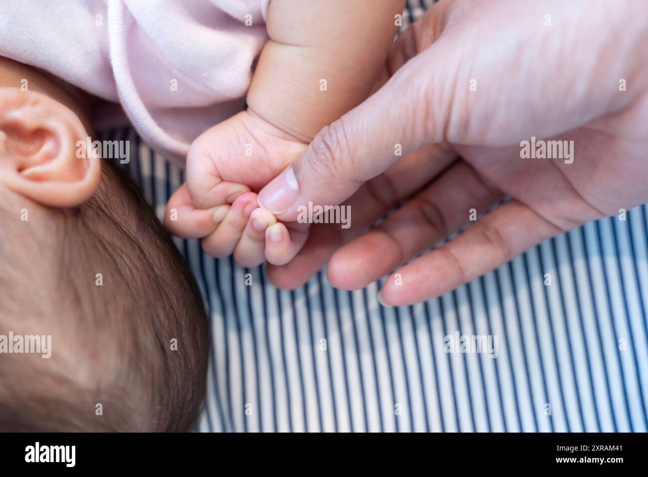 Asian parent hands holding newborn baby fingers, Close up mother's hand ...