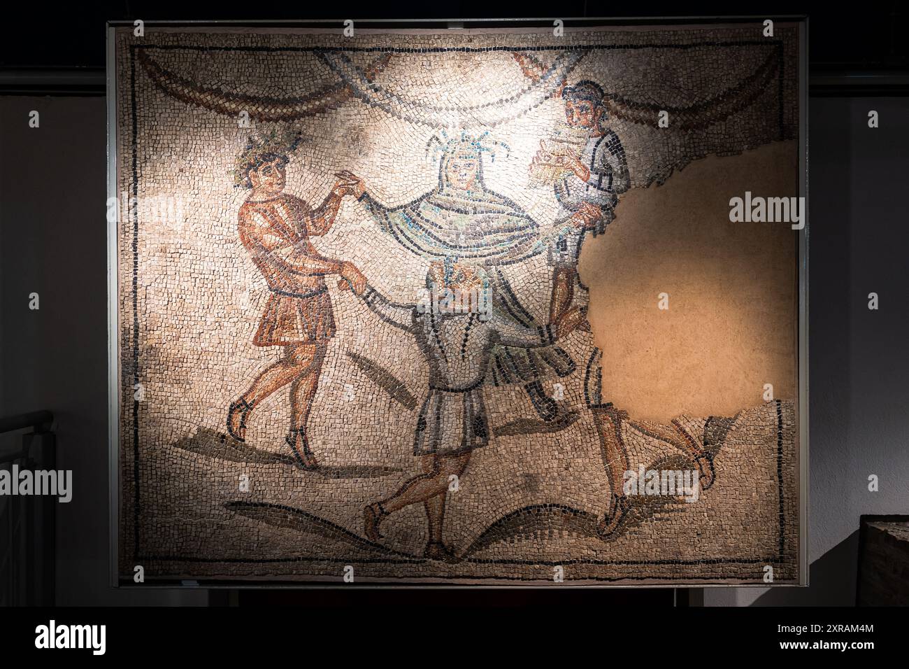 Ruins of medieval mosaic showing a group of men dancing while a flutist ...