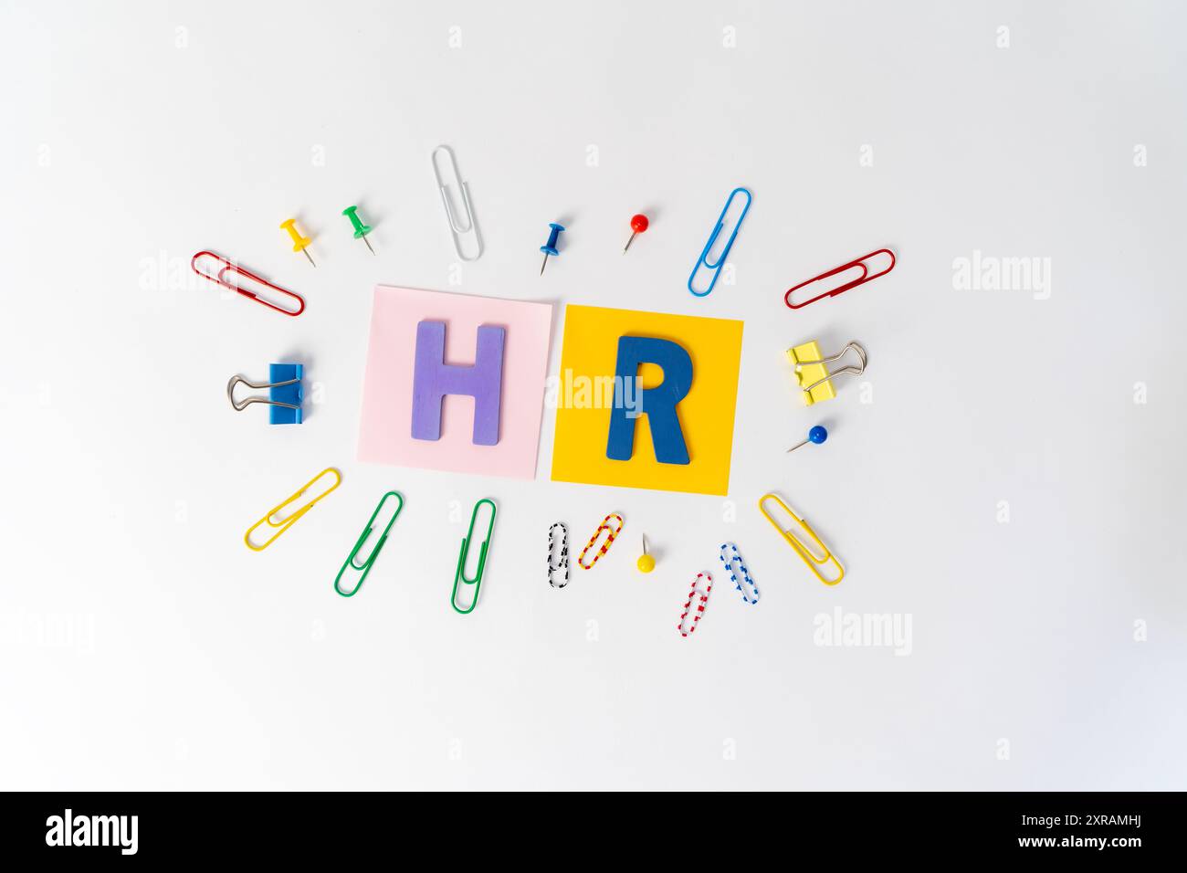 Human resource management concepts. HR colored wooden blocks with paper clips on a white ...