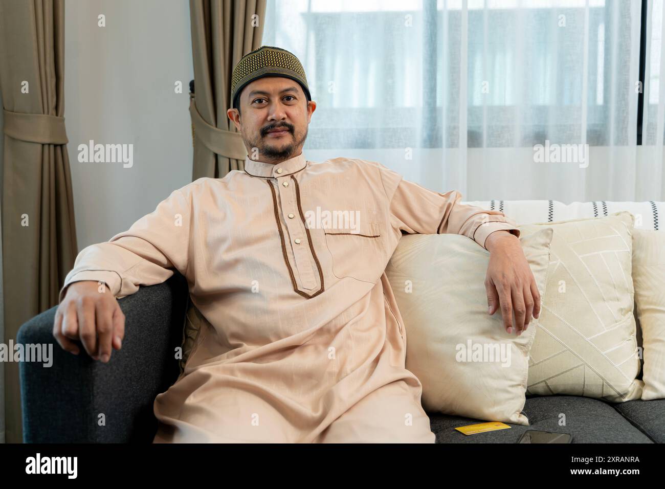 Portrait of handsome young Arab man smiling and looking at camera ...