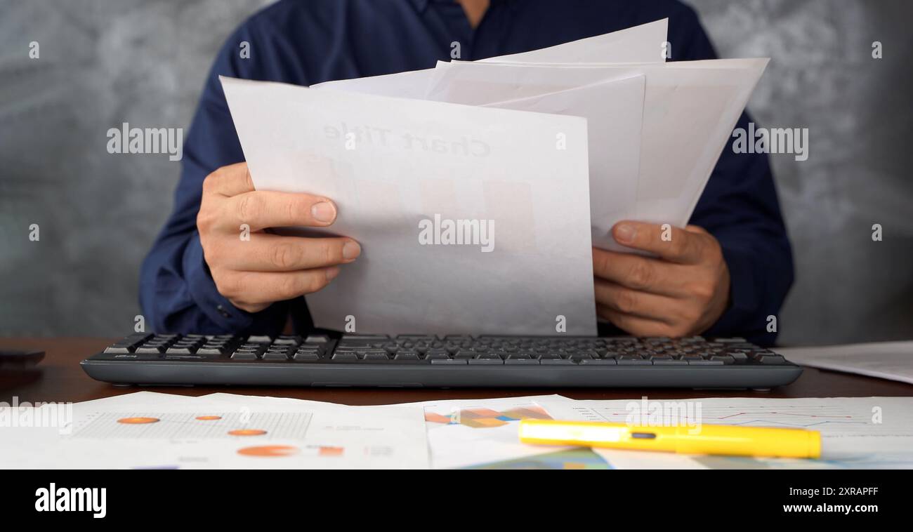 Focused businessman reviewing paper reports, received letter, notice ...