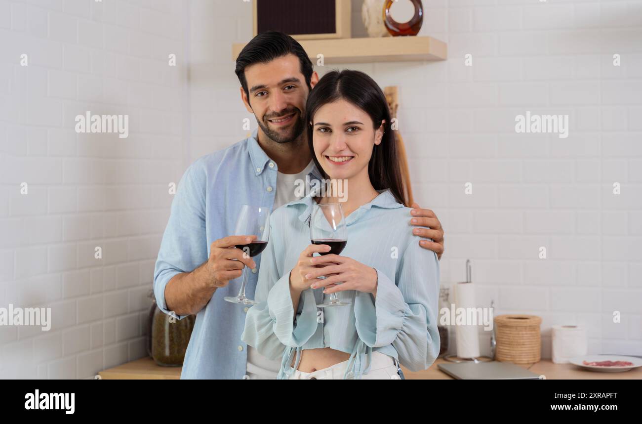 Happy couple holding wine glasses touching foreheads enjoying a tender ...