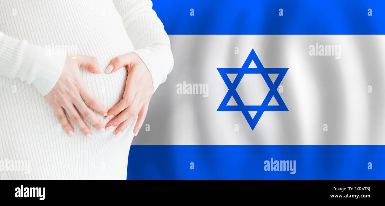 Pregnant woman making heart against her stomach on Israeli flag ...