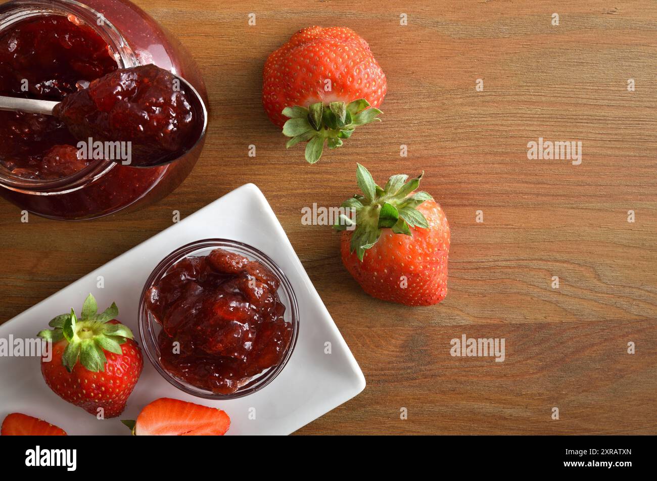Detail of containers with strawberry jam on wooden table with fruit ...