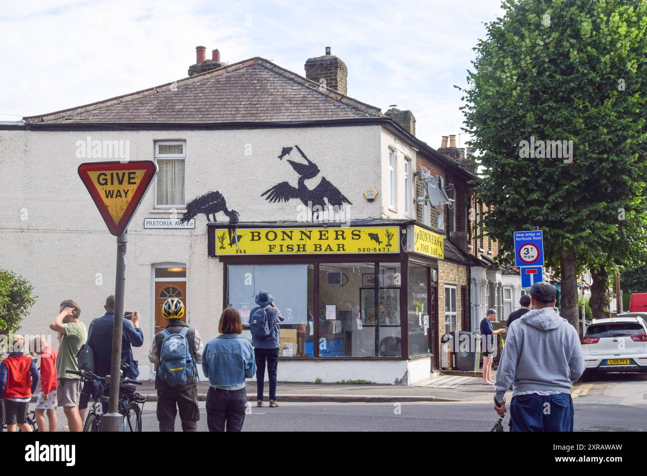 People gather to see another new Banksy artwork, depicting a pair of ...