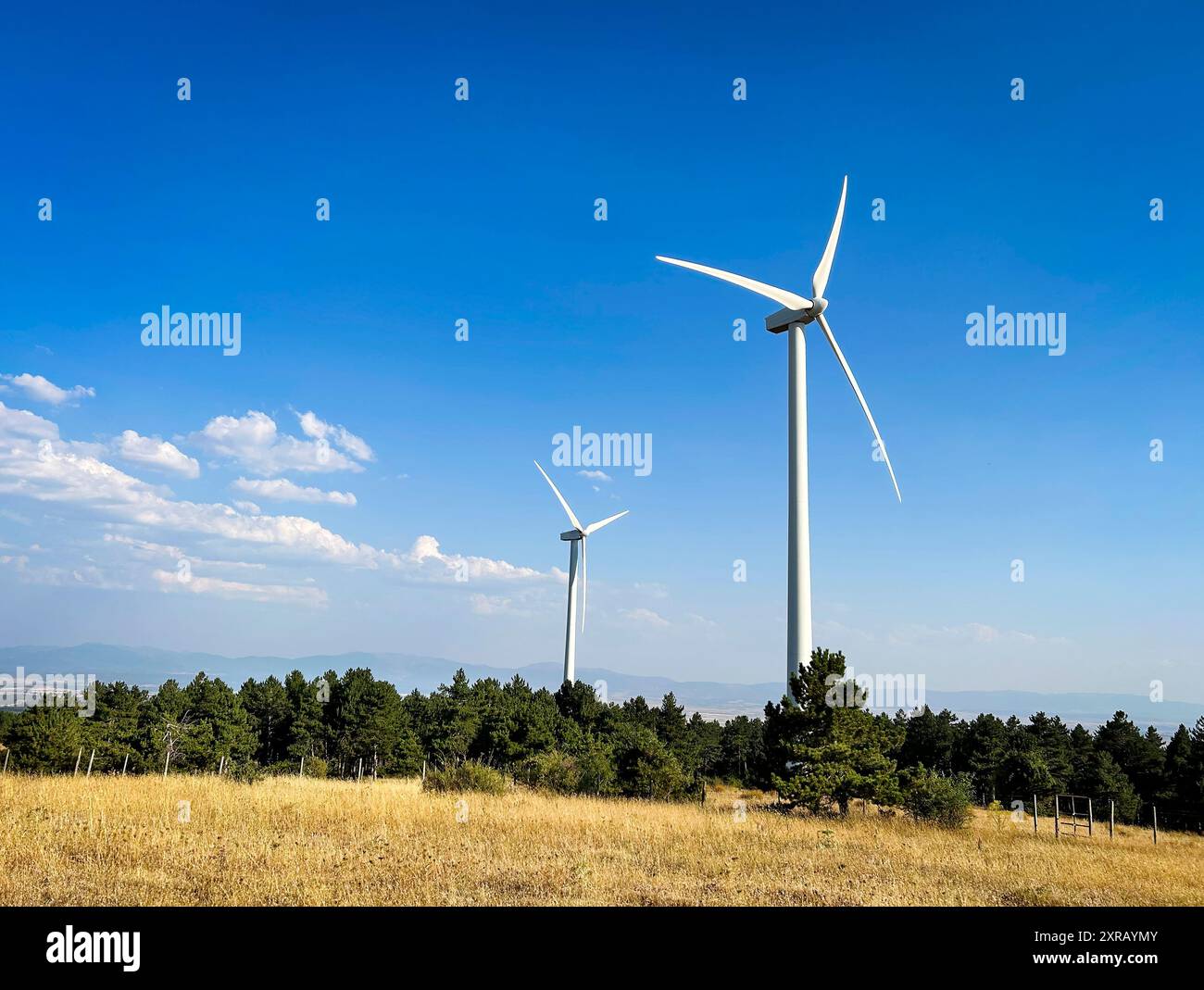Modern windmills installed on hills in the countryside amidst ...