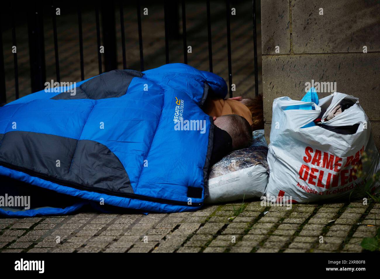 A homeless couple sleep on a corner as PSNI officers line the streets ...