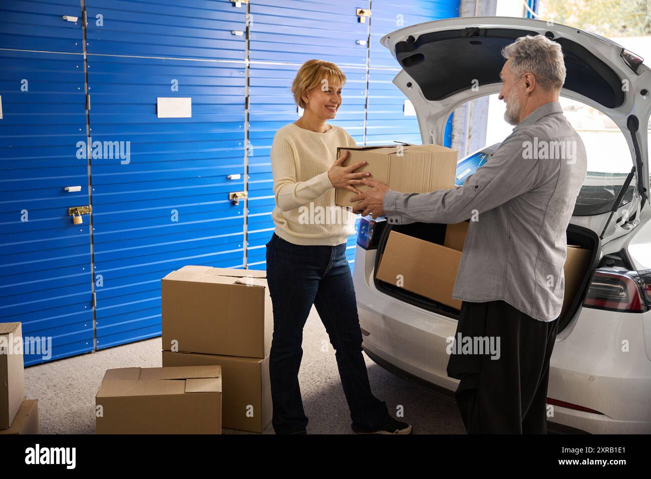 Female with cardboard boxes in self storage unit Stock Photo - Alamy