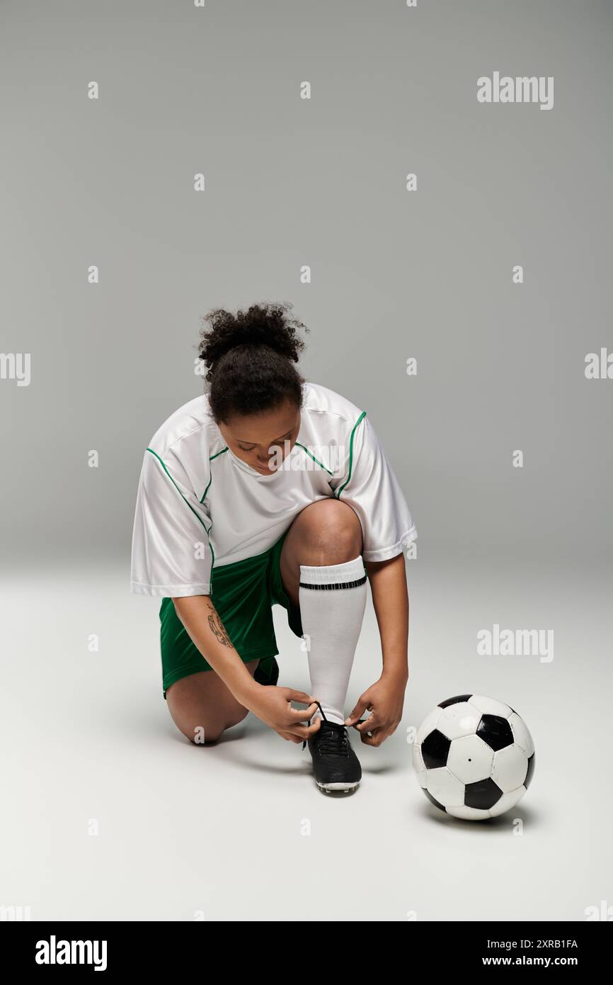 A female athlete prepares for a soccer game by tying her shoe Stock ...