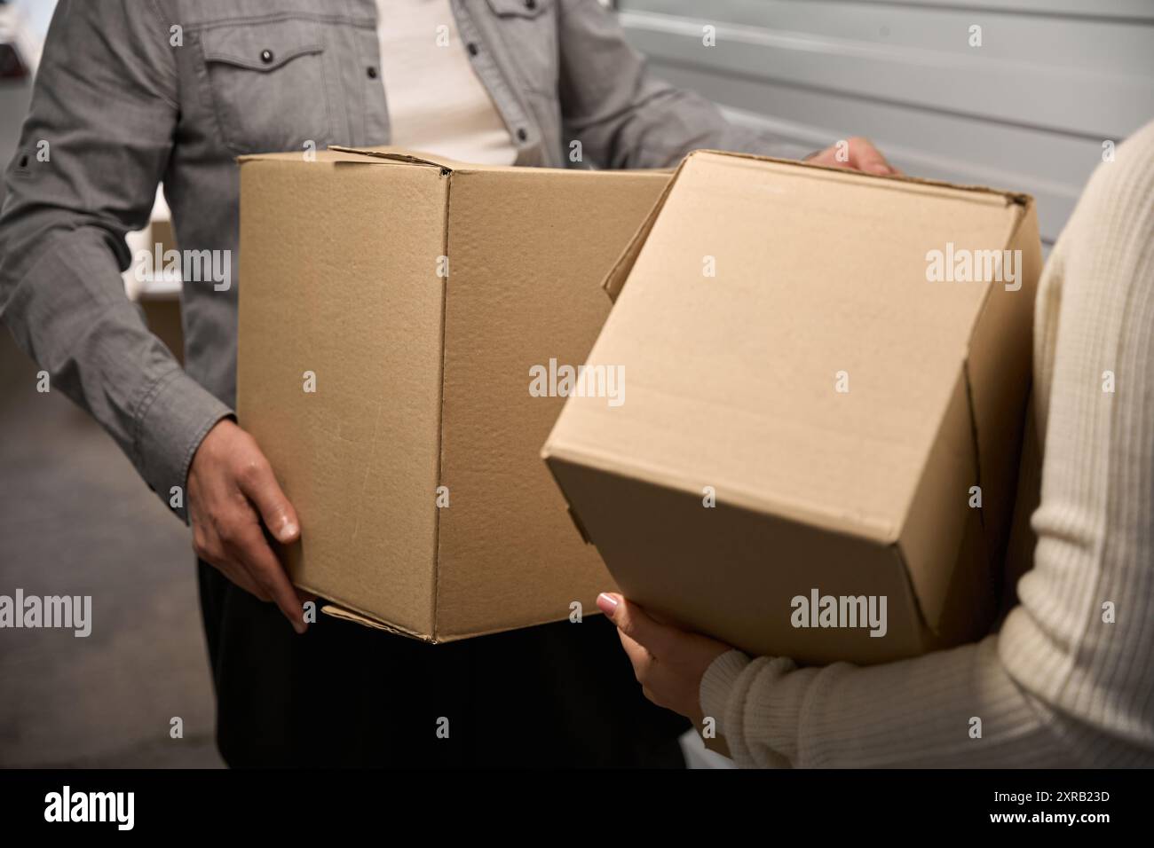Man and lady carry boxes in storage unit Stock Photo - Alamy