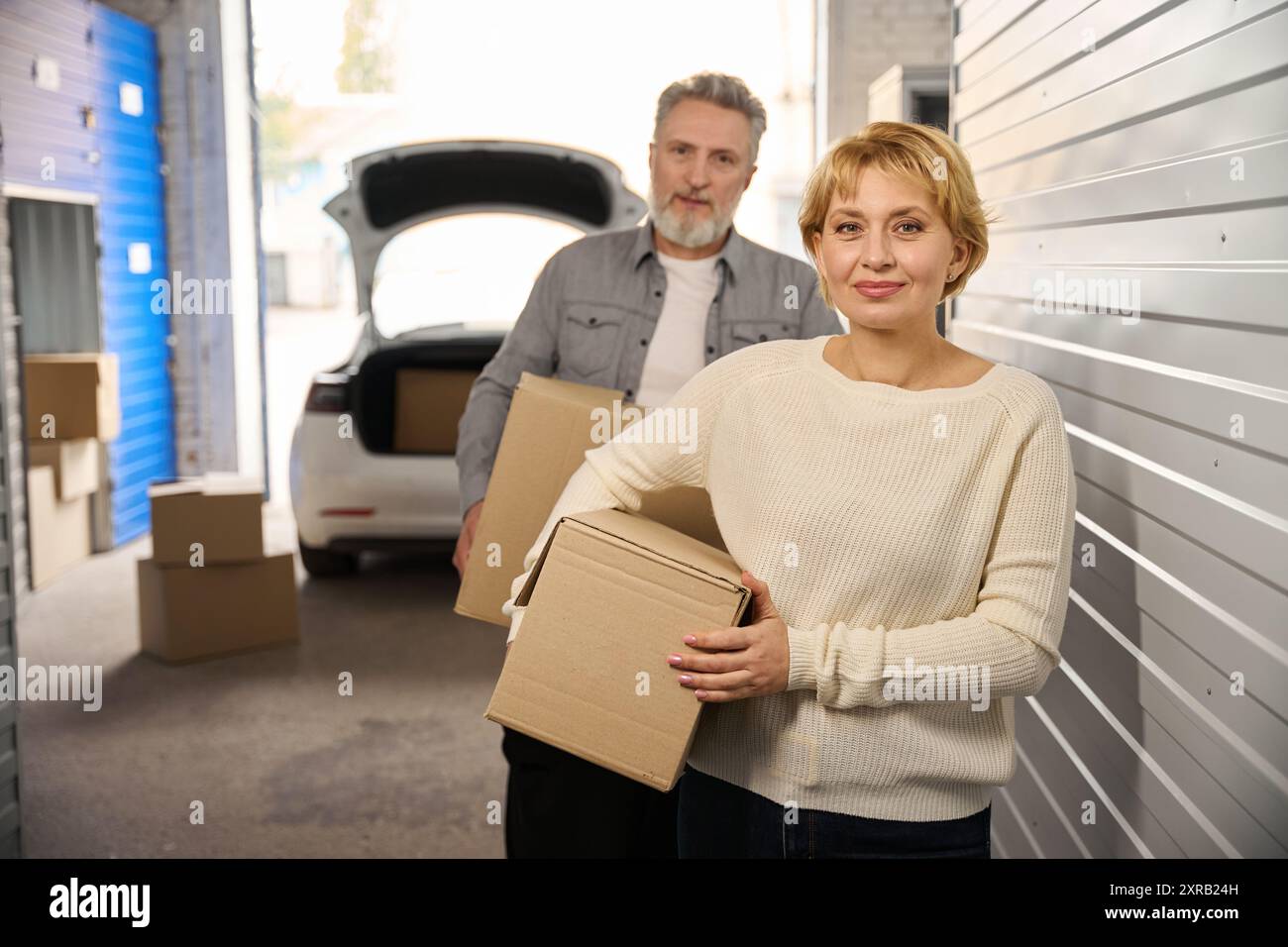 Man and female carry boxes in storage unit Stock Photo - Alamy