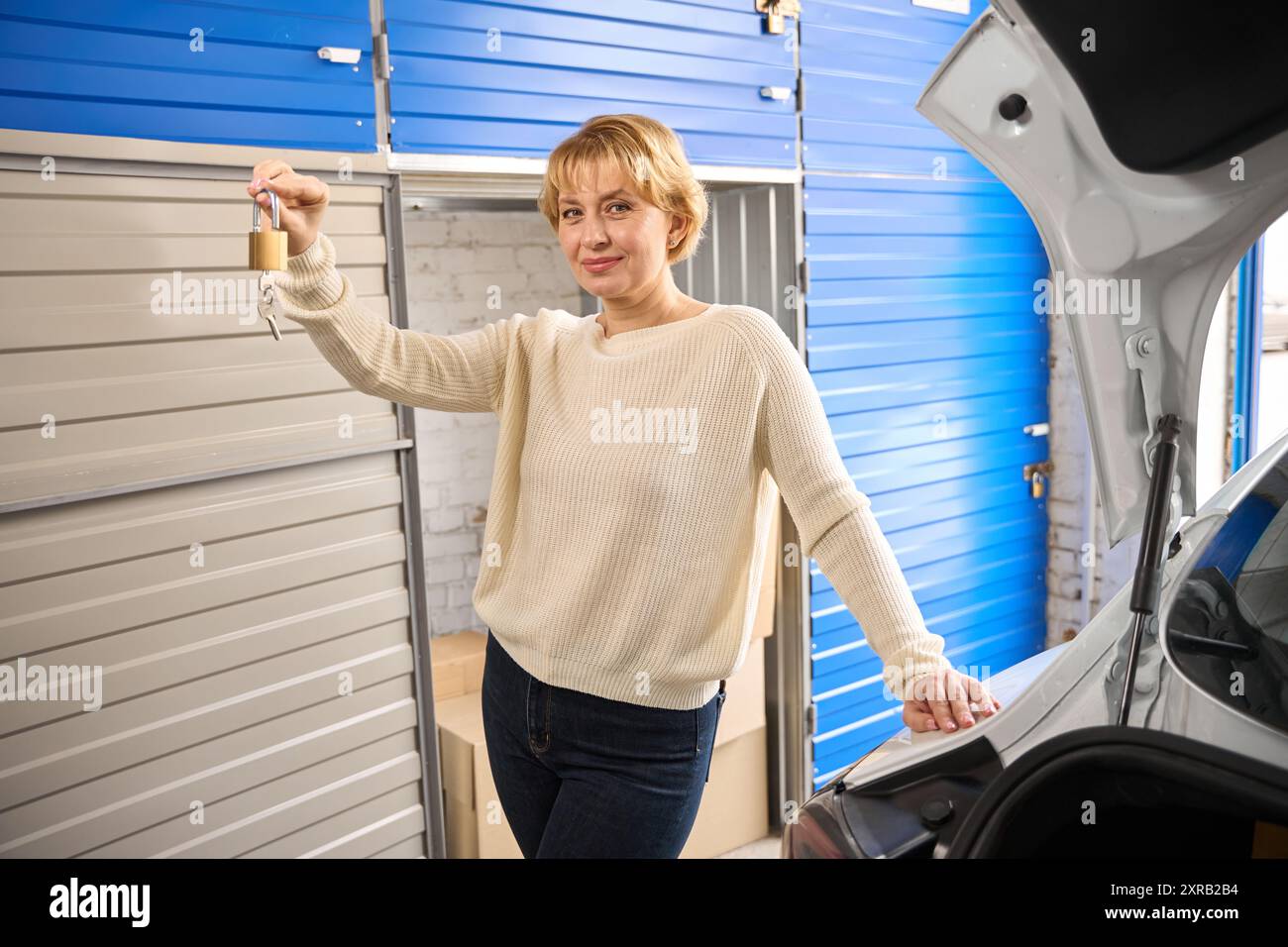 Female hold lock, working in storage unit Stock Photo - Alamy