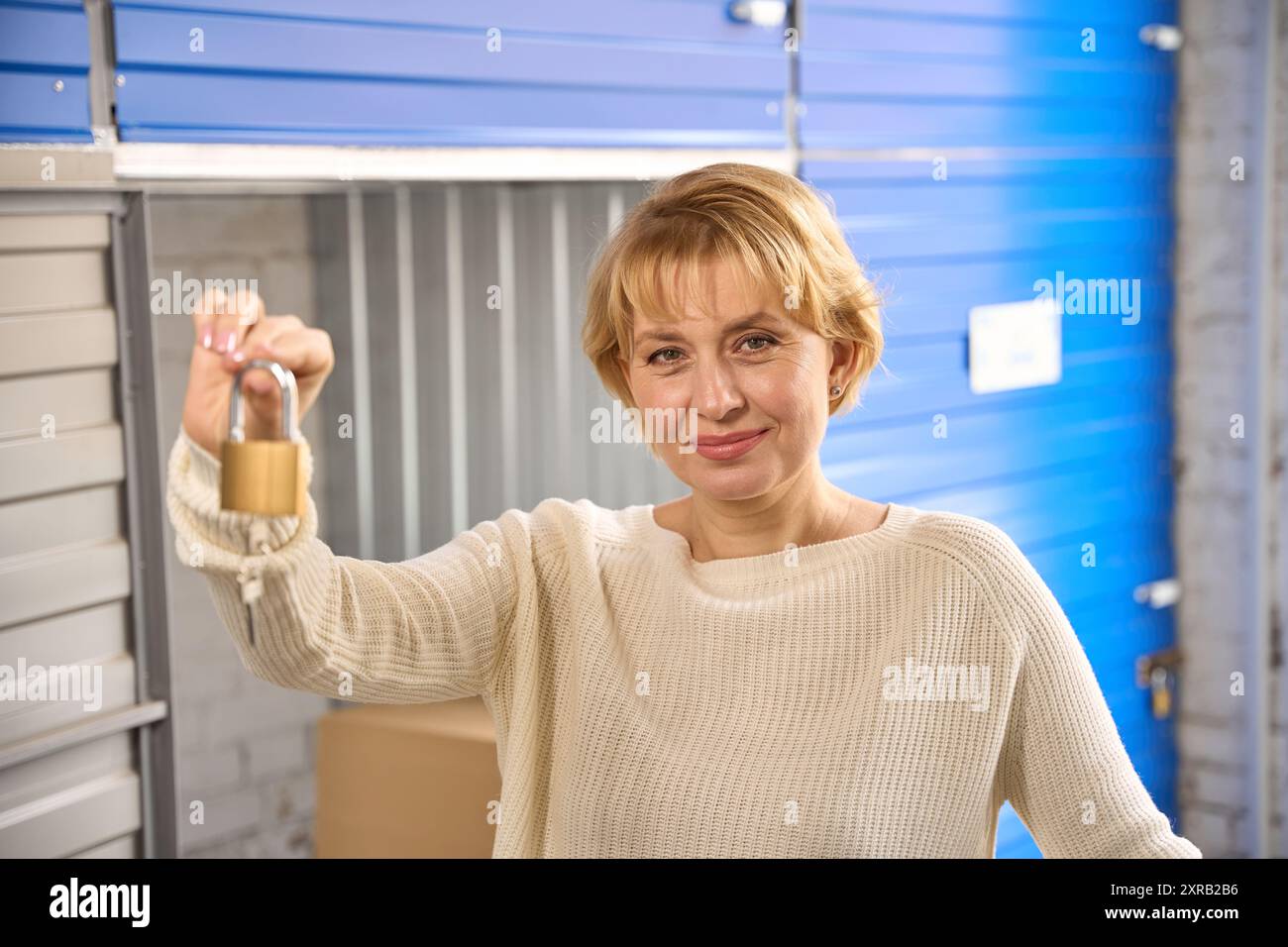 Lady hold lock, working in storage unit Stock Photo - Alamy