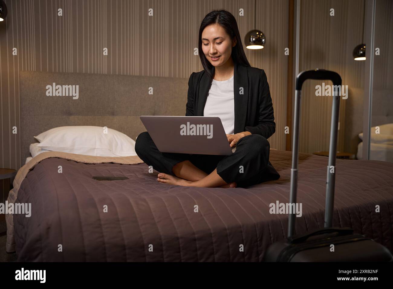 Positive woman booking room in hotel before the journey abroad Stock ...