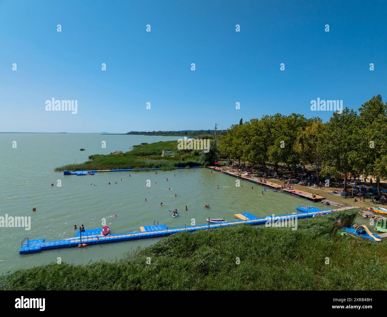 Beach in Lake Balaton. People bathing in the water of lake in hot ...