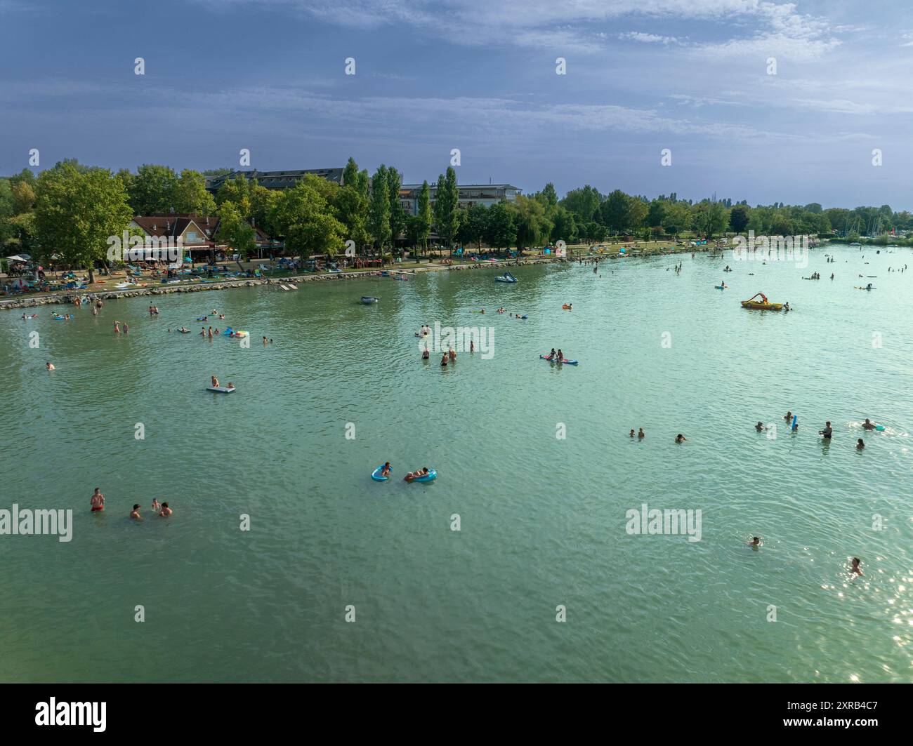Beach in Lake Balaton. People bathing in the water of lake in hot ...