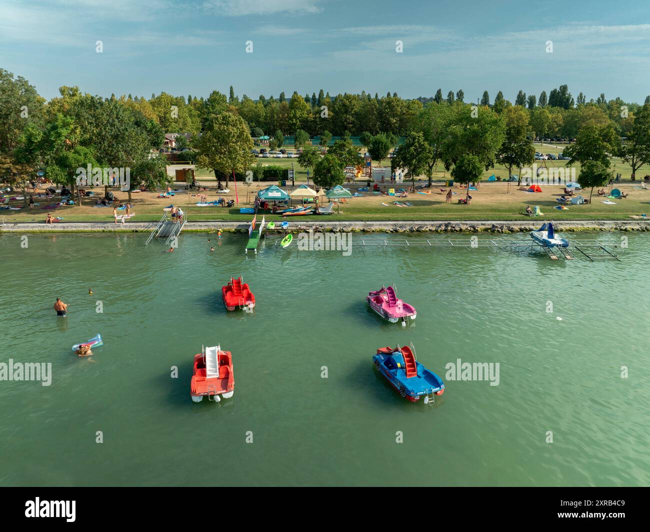 Beach in Lake Balaton. People bathing in the water of lake in hot ...