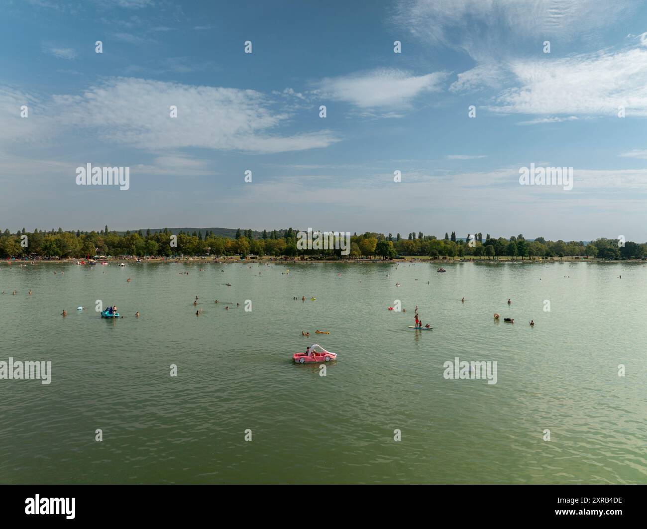 Beach in Lake Balaton. People bathing in the water of lake in hot ...