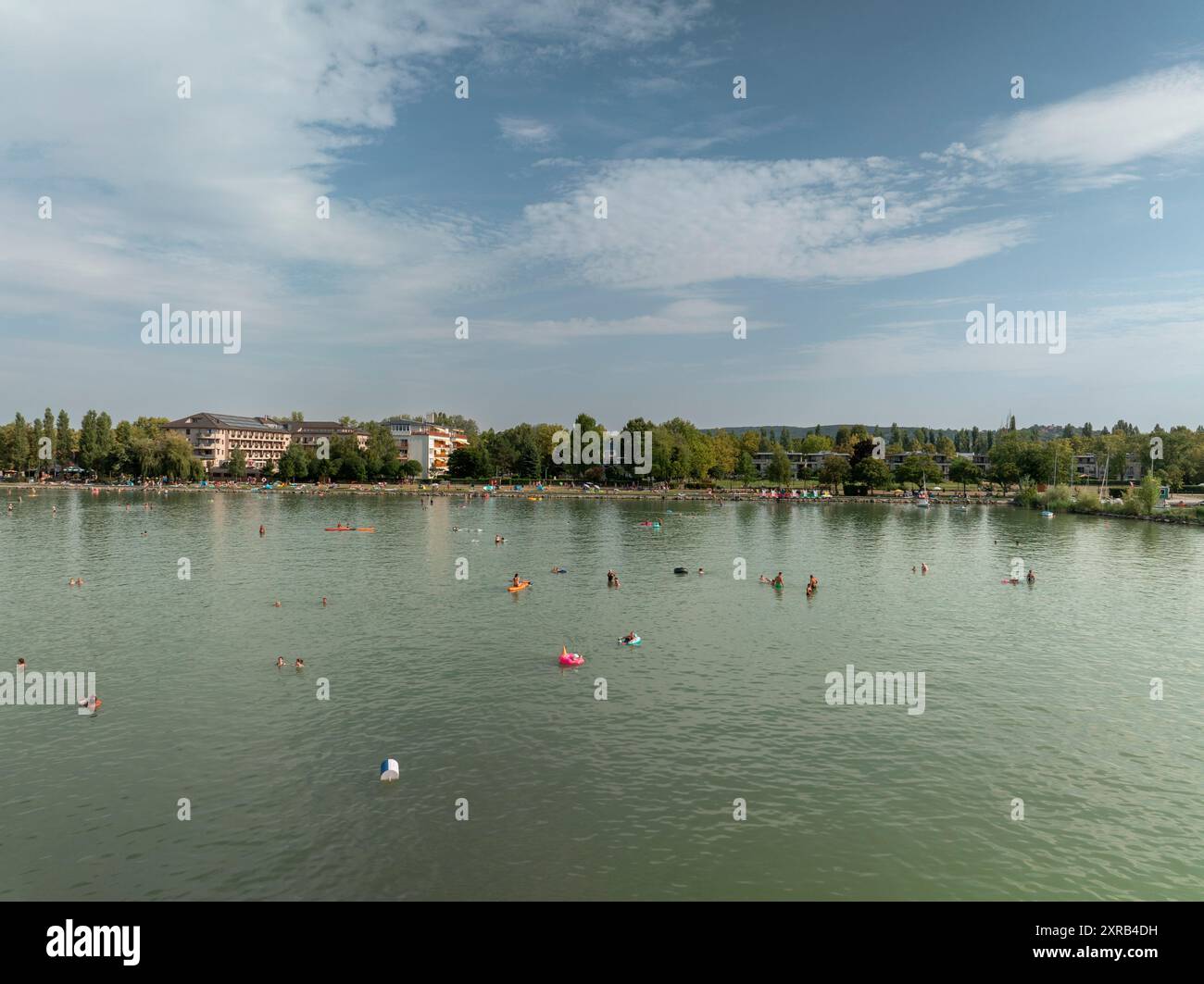 Beach in Lake Balaton. People bathing in the water of lake in hot ...