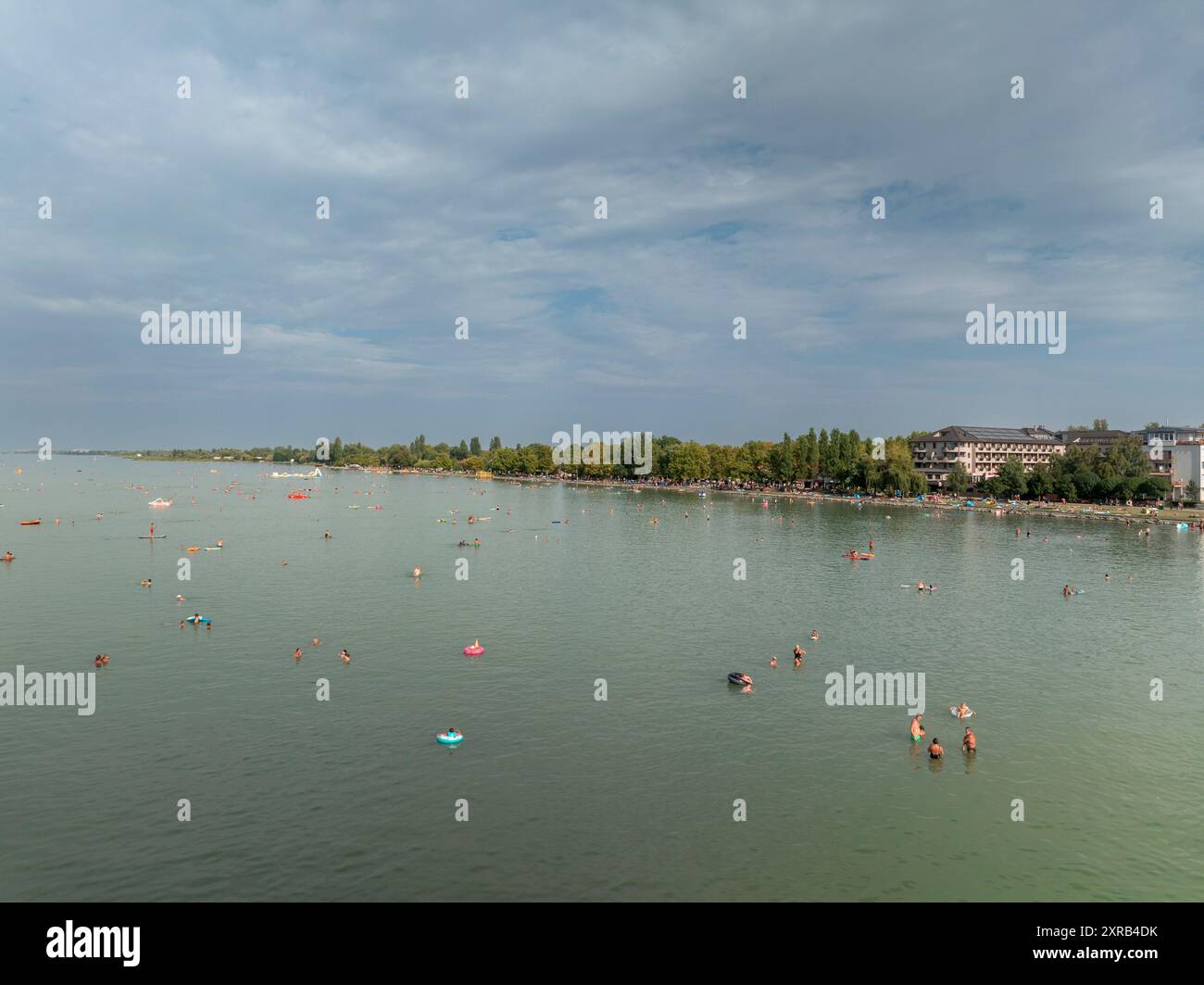 Beach in Lake Balaton. People bathing in the water of lake in hot ...