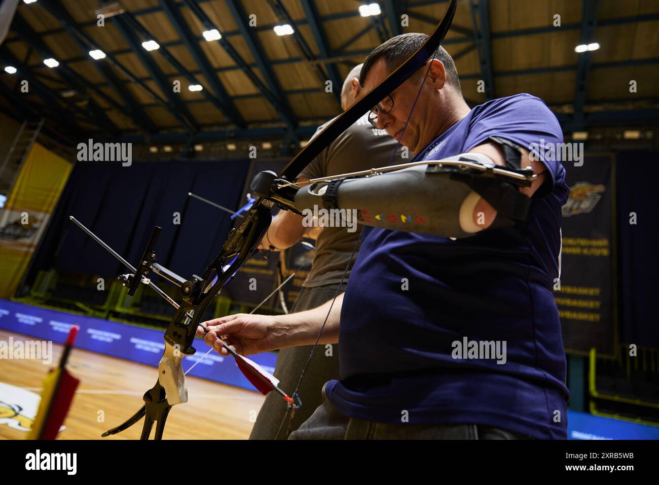 Para archer with one arm prepares to shoot the target with bow and ...